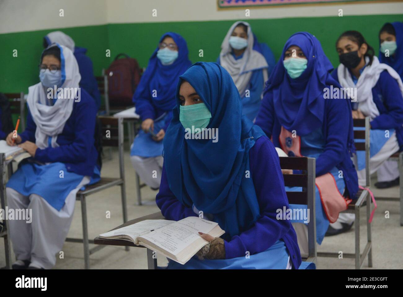 Pakistani students wearing facemasks to attend their first day of ...
