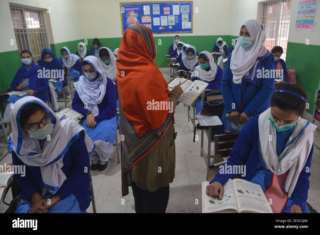 Pakistani students wearing facemasks to attend their first day of ...