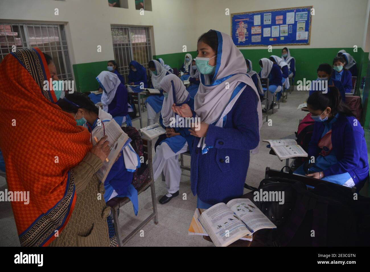 Pakistani students wearing facemasks to attend their first day of ...