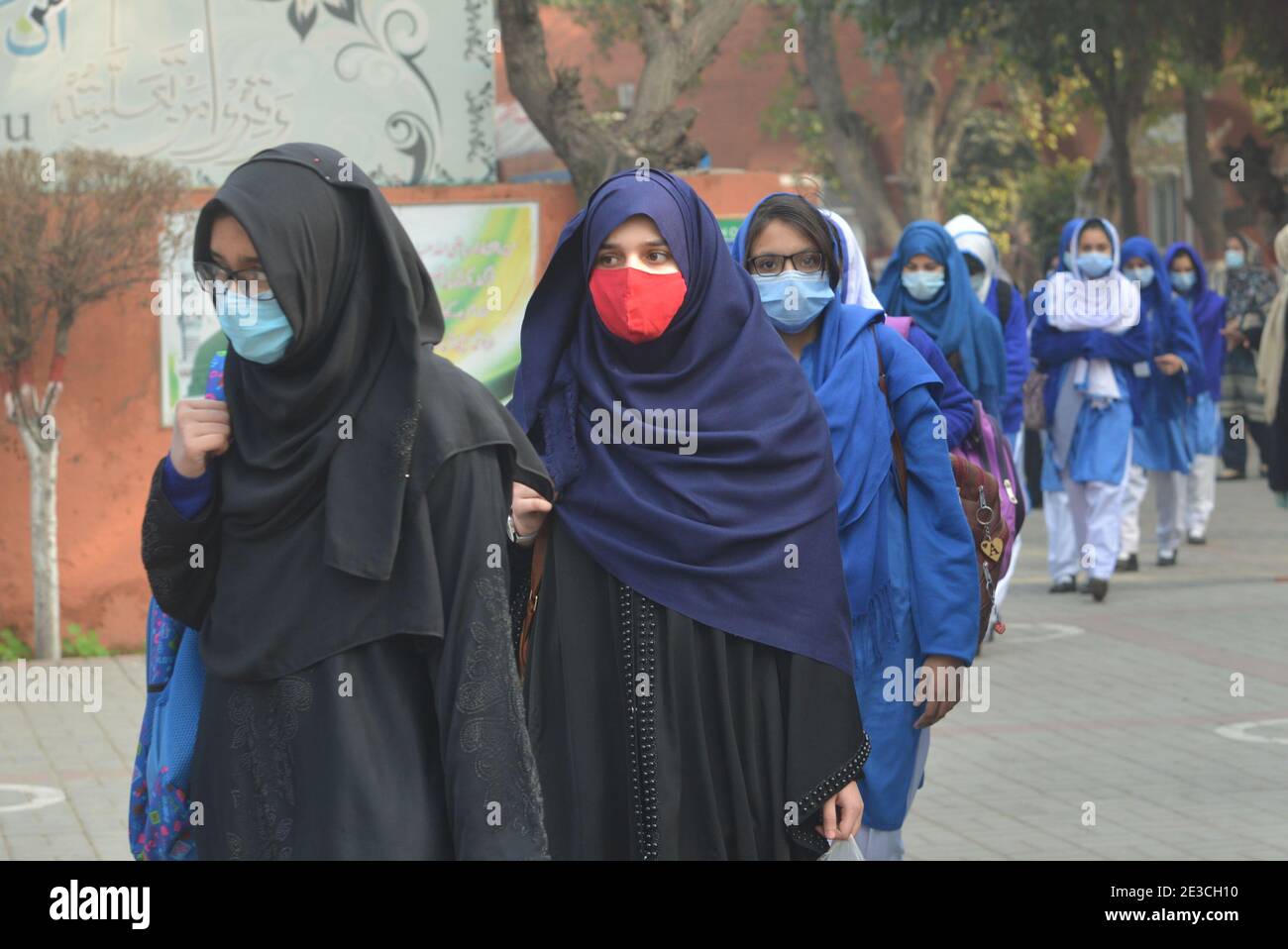 Pakistani students wearing facemasks to attend their first day of ...
