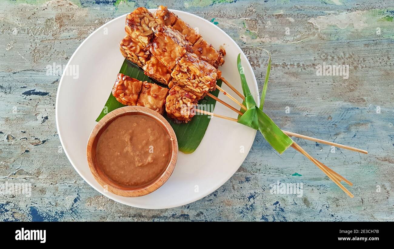 Exotic Indonesian Style vegetarian satay sticks with peanut sauce on a ...