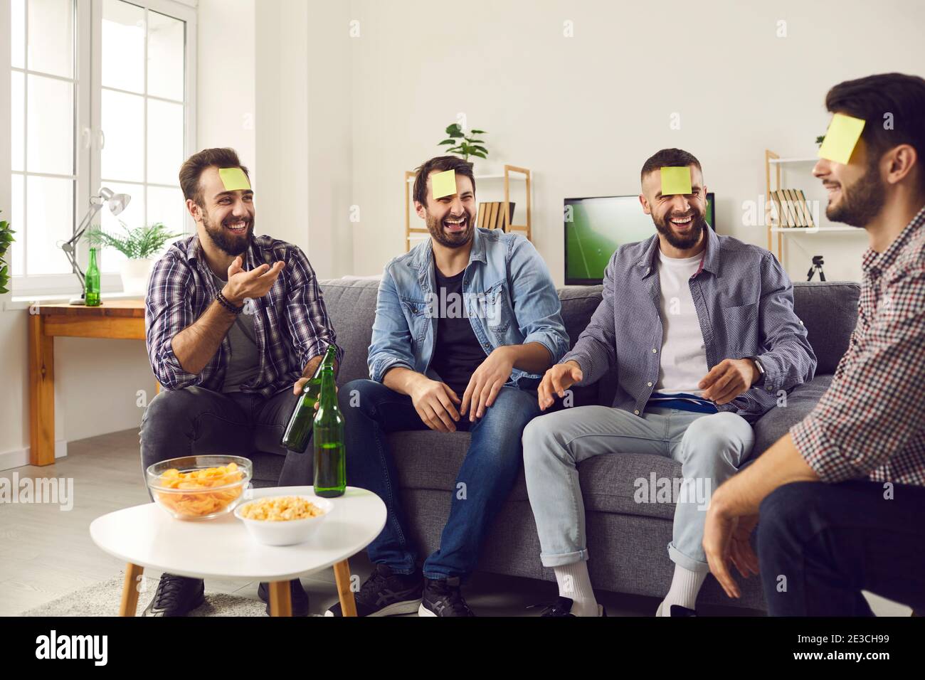 Friends with sticky notes on foreheads playing Who Am I game and having ...