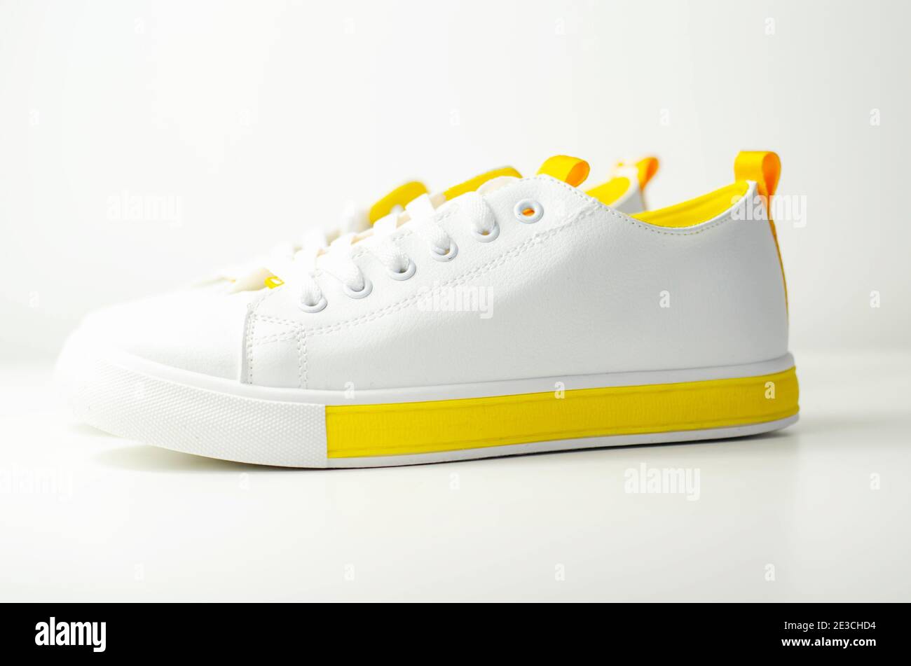 White sneakers with yellow accents, classic sports shoes Stock Photo ...
