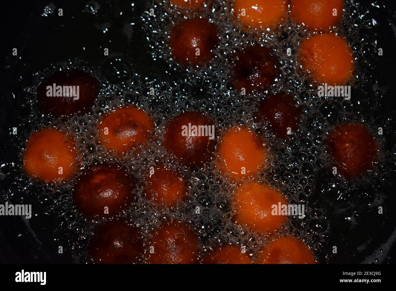 Top view closeup view of puff puff balls in oil being cooked in the pan ...