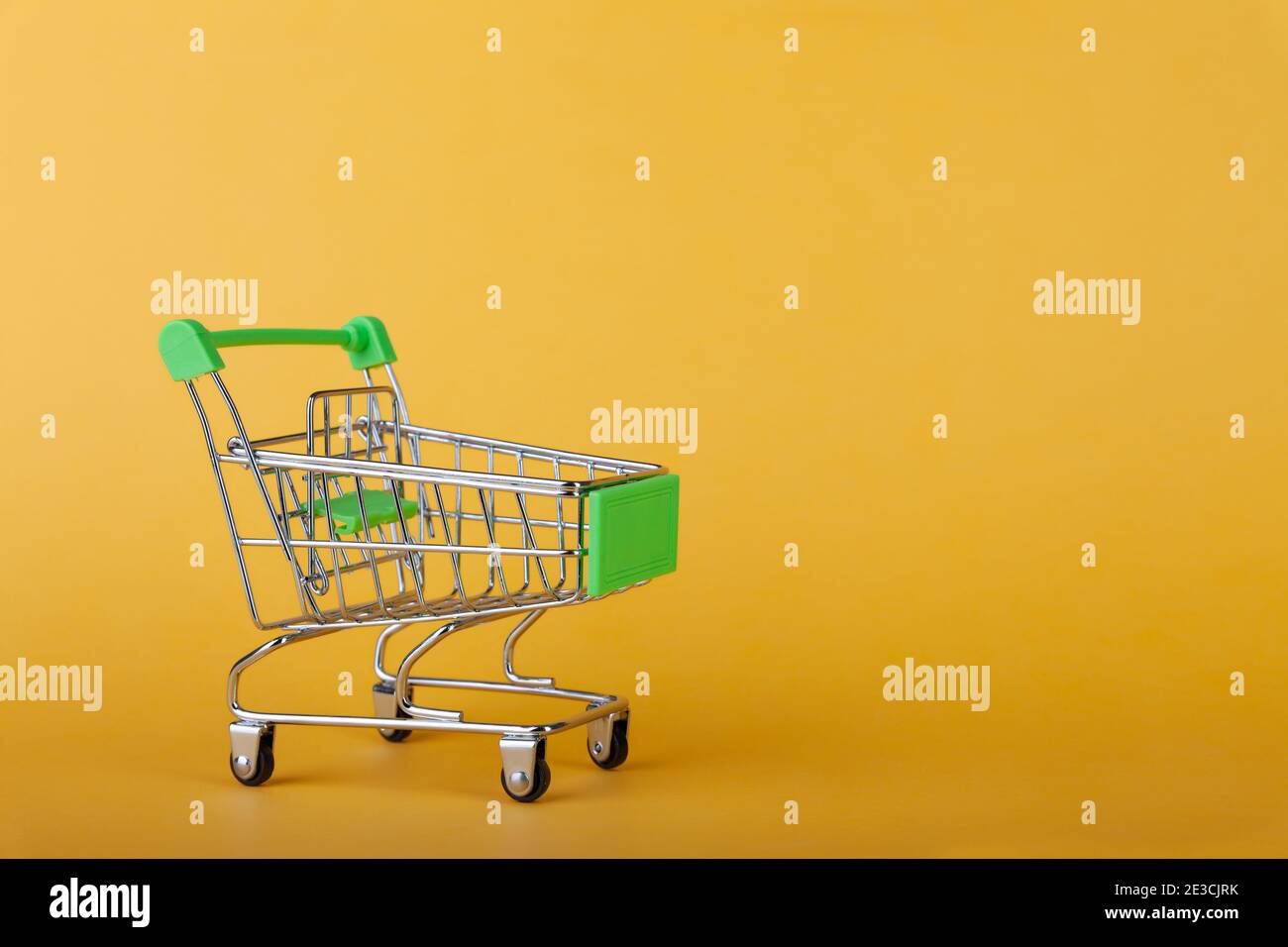 Empty supermarket shopping grocery cart on yellow background, concept ...