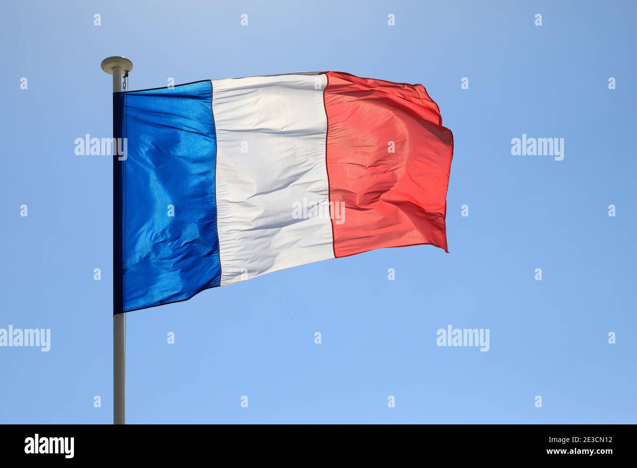 The three-colored national Flag of France waves in the wind and is ...