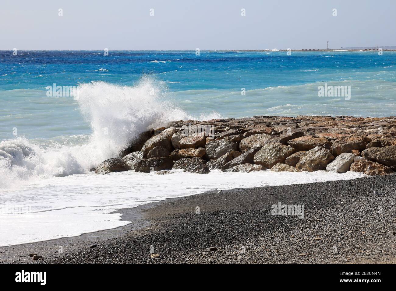 Storm waves break on a massive breakwater which serves to protect the ...