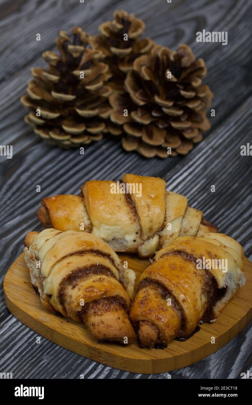 Cinnamon croissants. Rich pastries. Nearby pine cones. Close-up shot ...