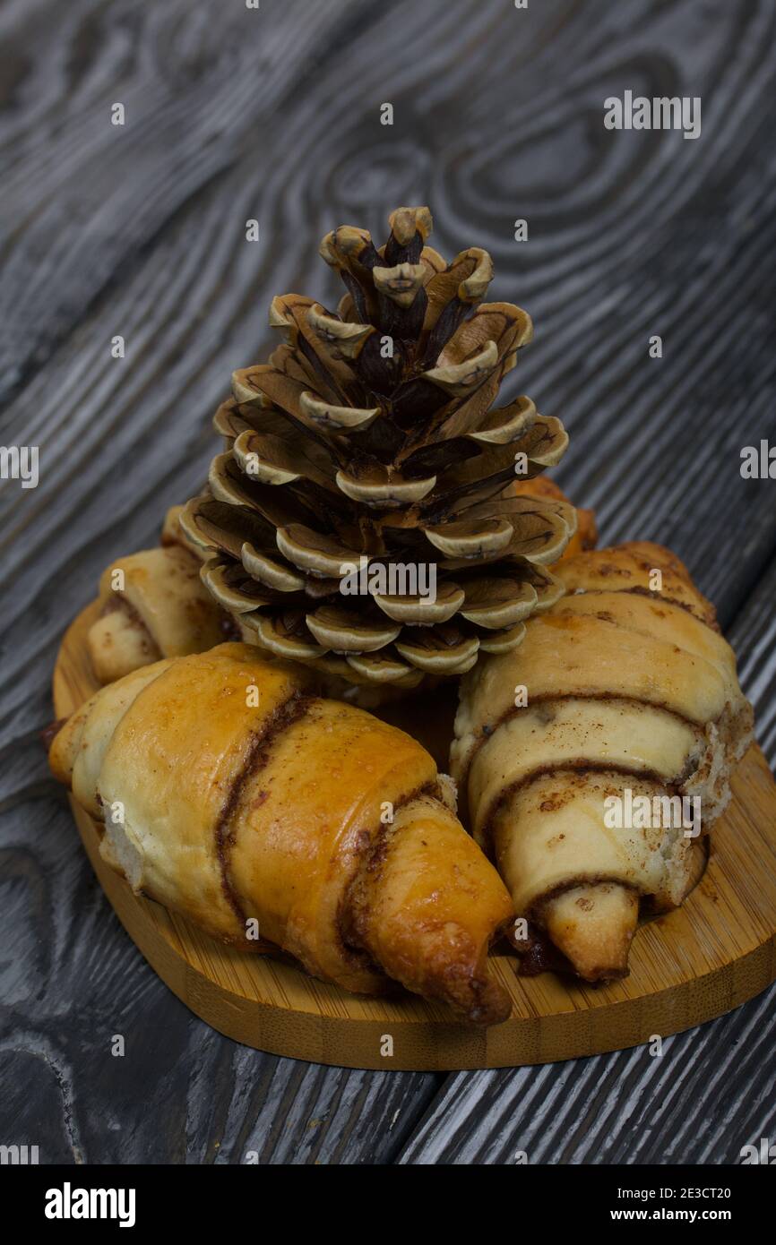 Cinnamon croissants. Rich pastries. Nearby pine cones. Close-up shot ...