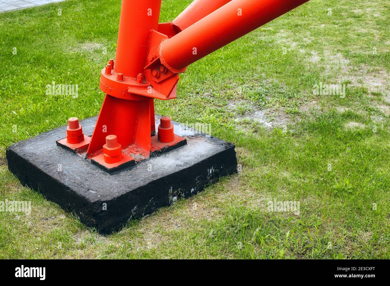 This is a red metal support or pole attached to the concrete base with ...