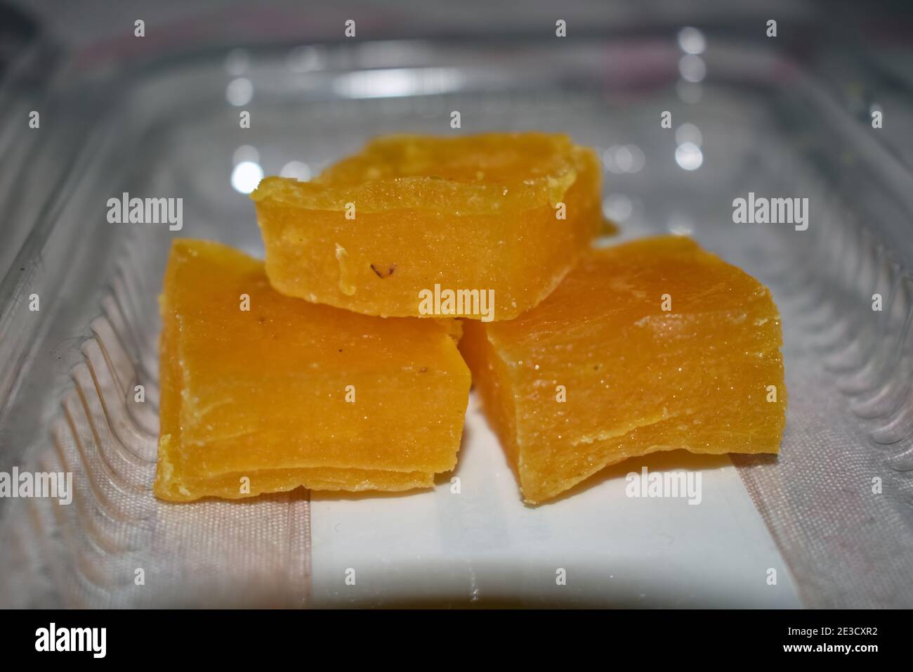 Top view closeup of three pieces of Custard Powder Halwa placed in a ...