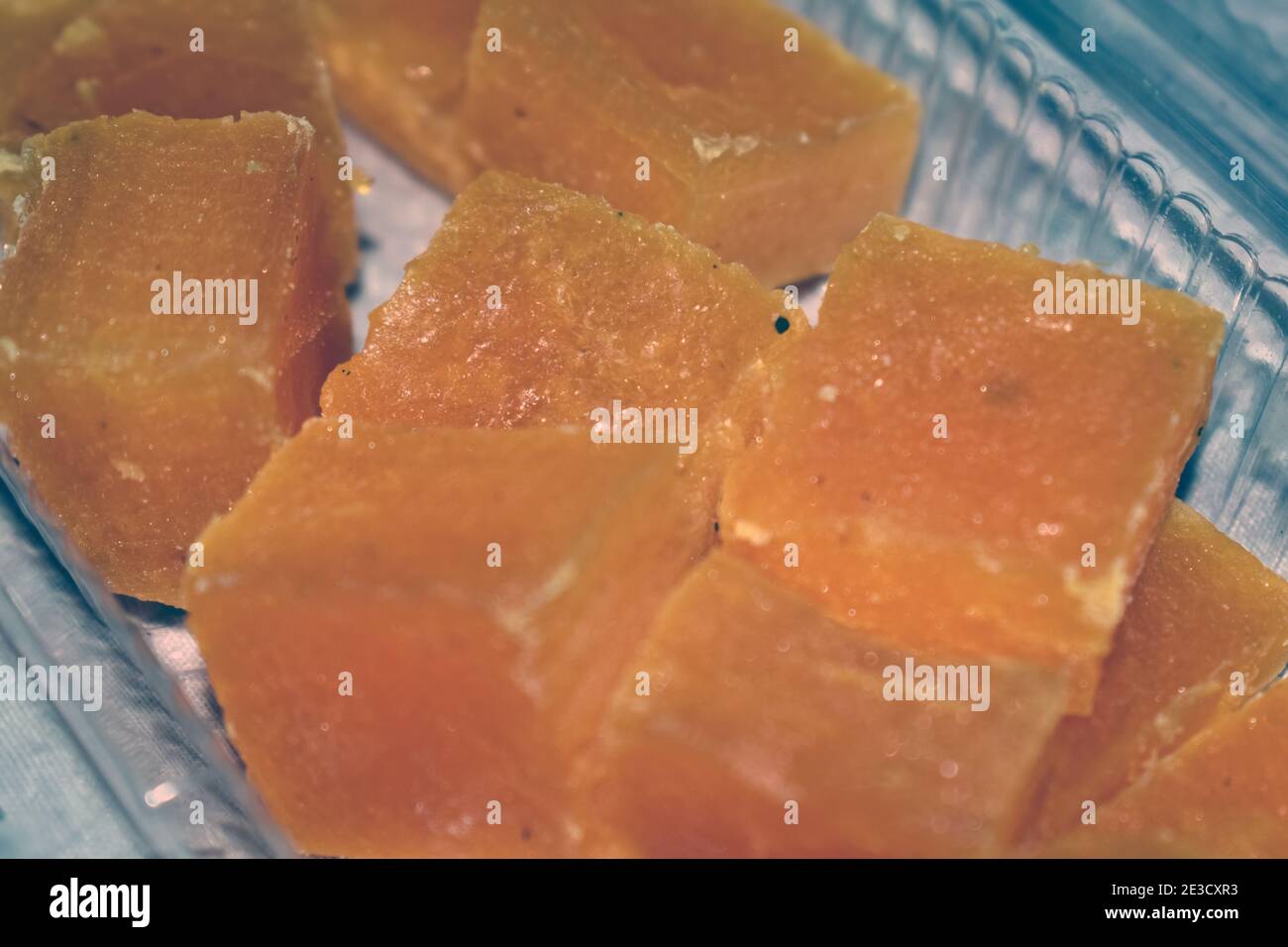 Top view closeup of pieces of Custard Powder Halwa placed in a glass ...