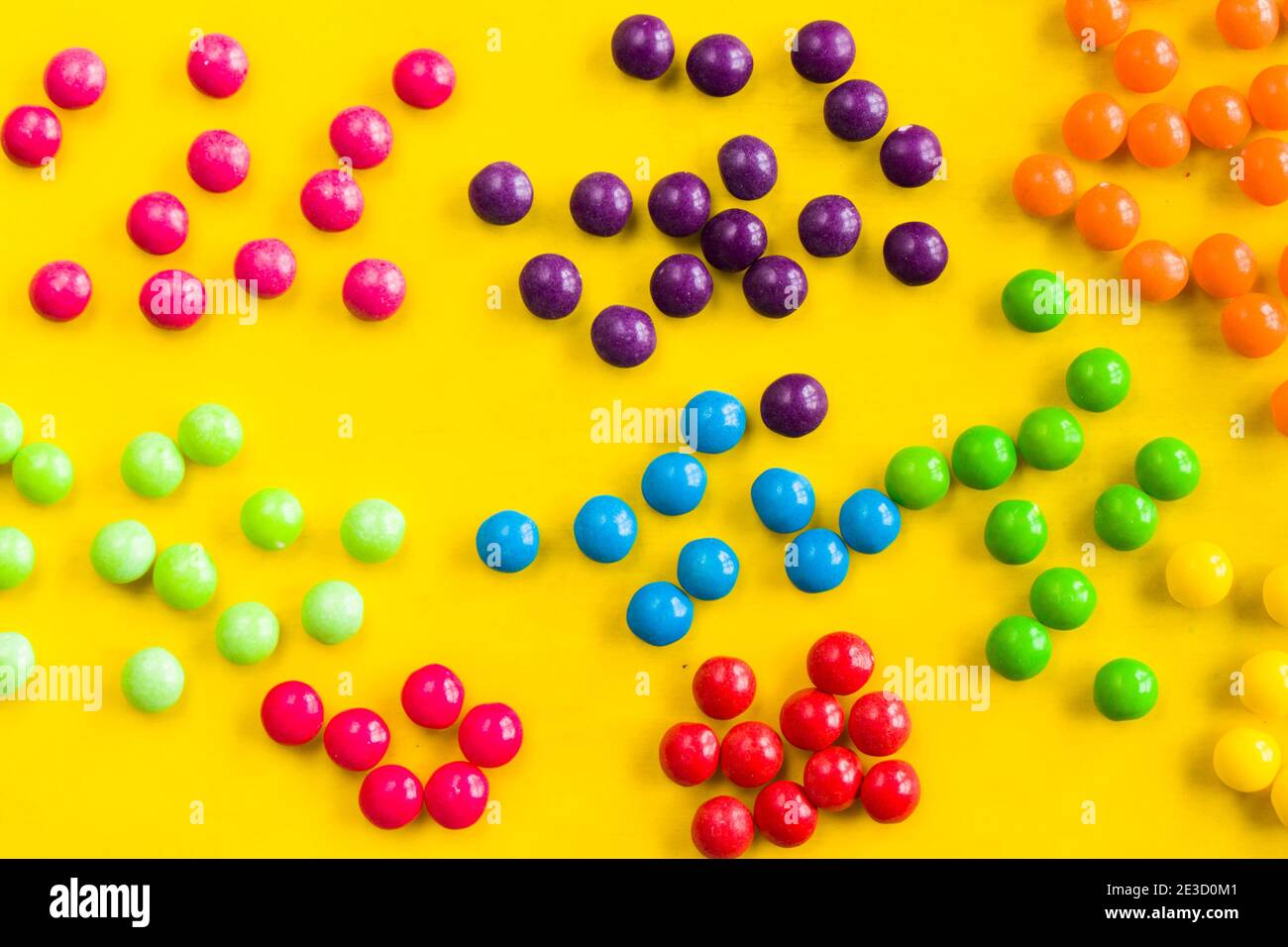 Skittles candy on the yellow table, colorful sweet candy background ...