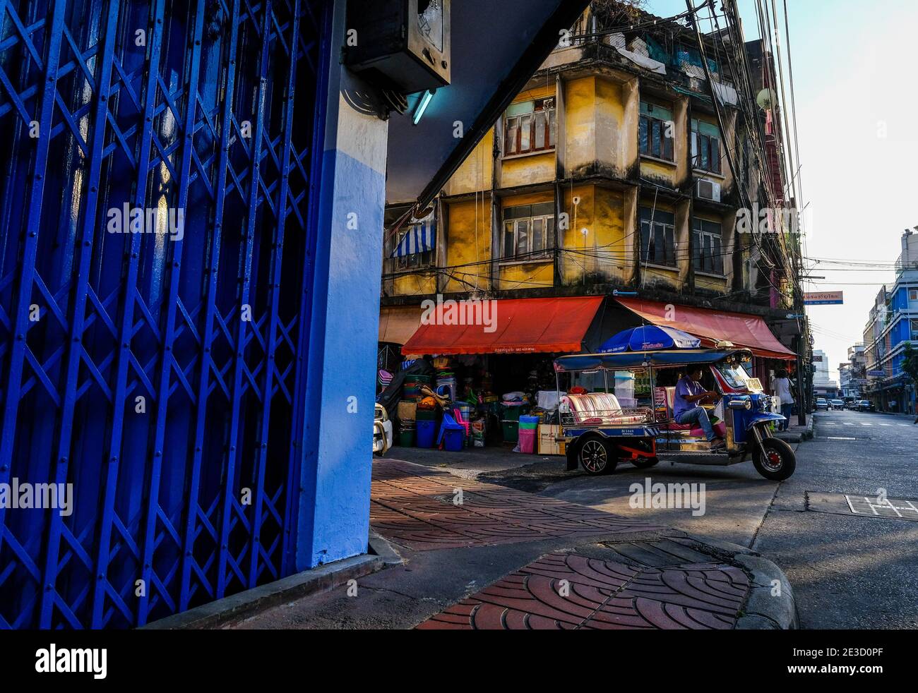 A blue tuk tuk pulls out from a junction in Chinatown, Bangkok ...