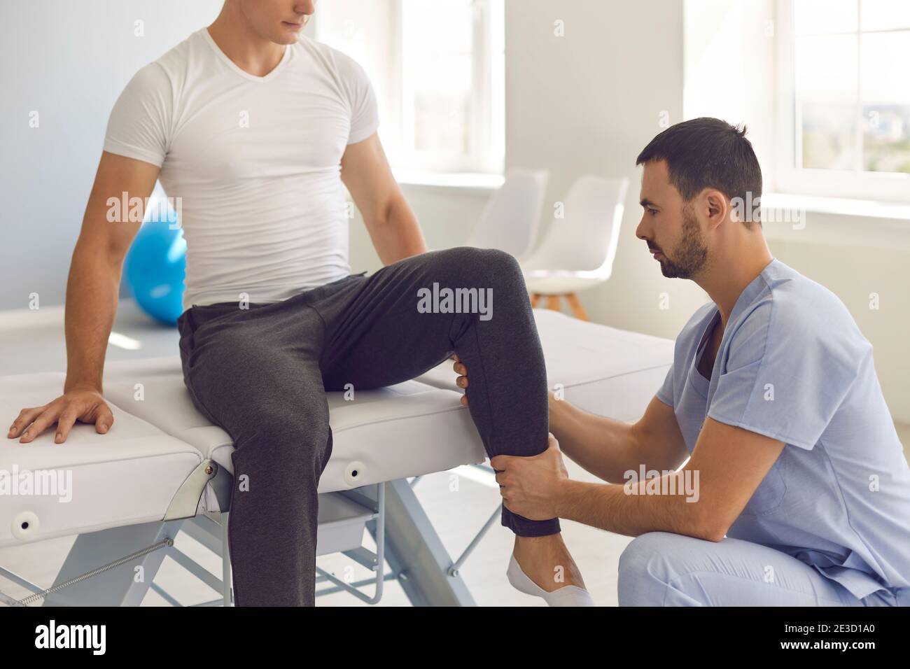 Man professional osteopath checking and fixing man patients legs joints ...