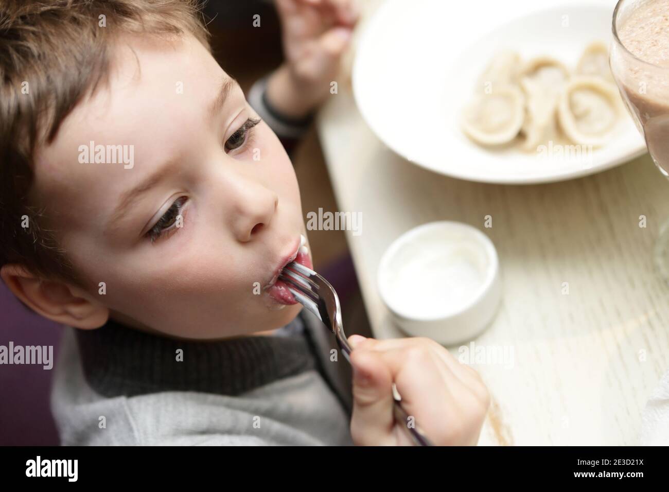 Child eating meat dumplings in a cafe Stock Photo - Alamy