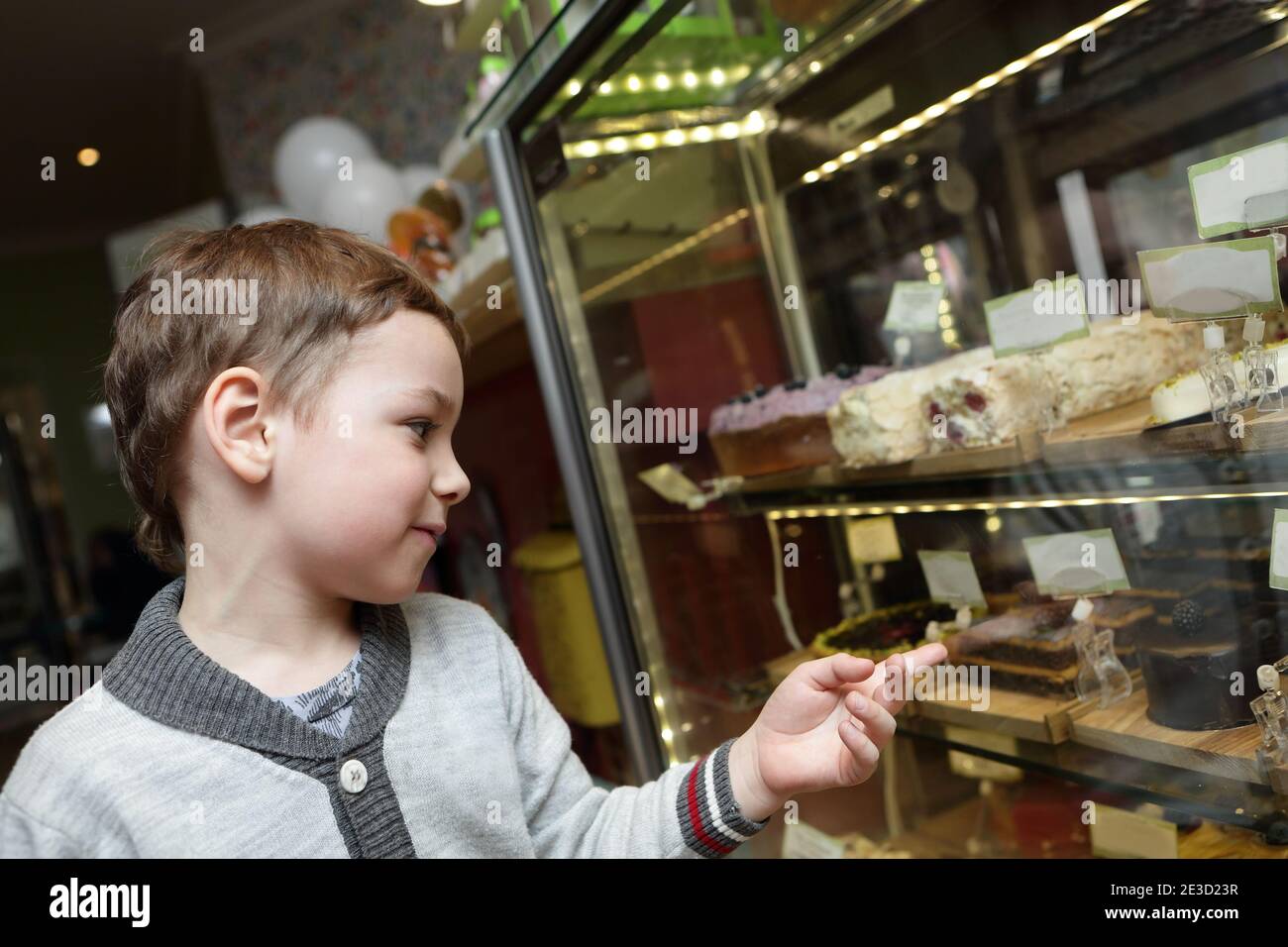 Boy choosing a cake in the cafe Stock Photo - Alamy