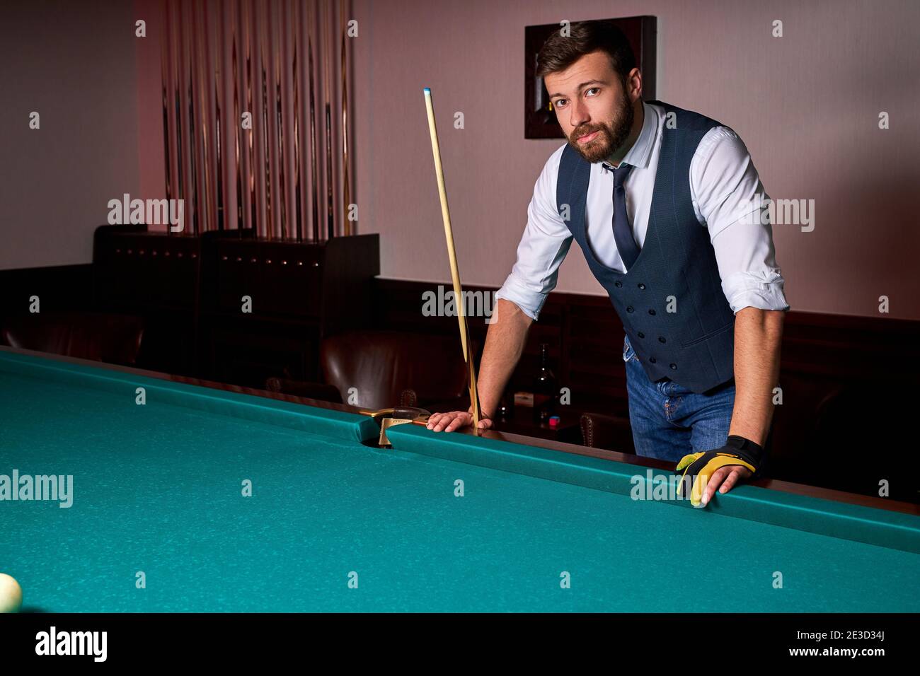 male standing next to billiards table, looking at camera, posing, in ...