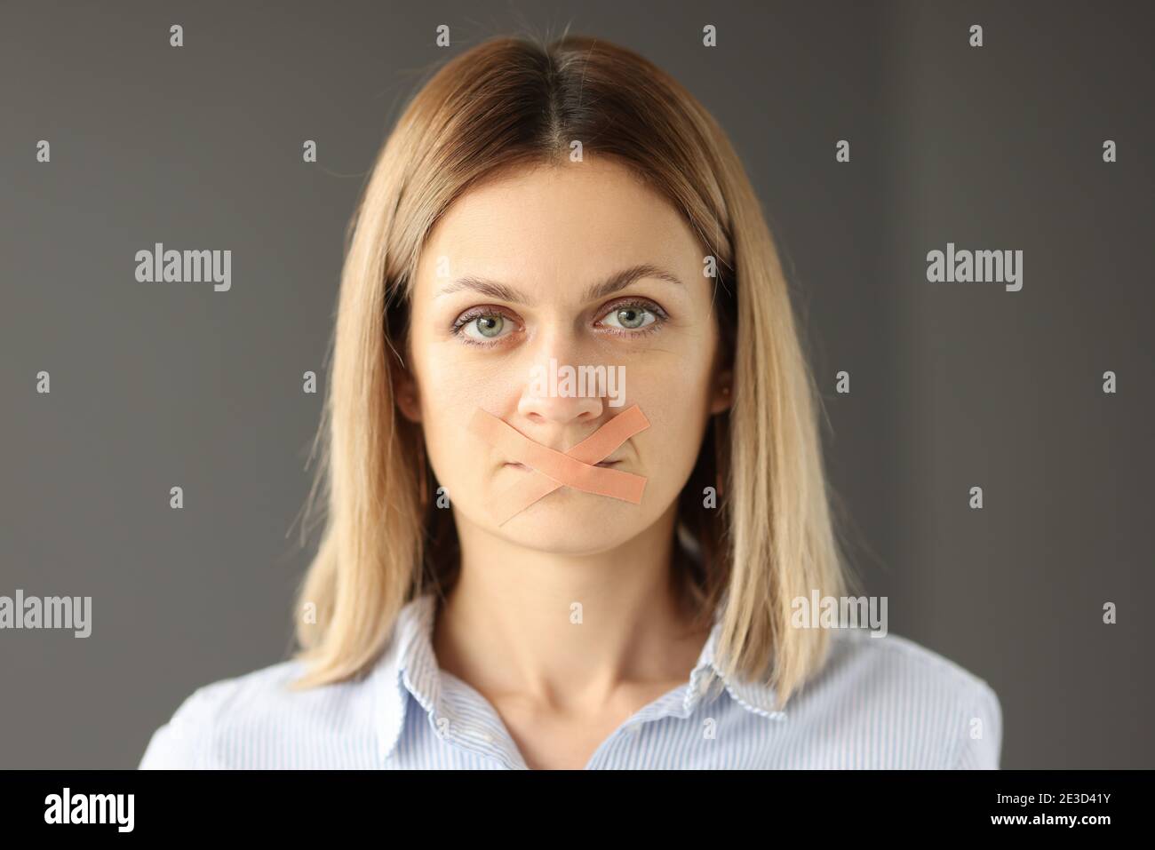 Portrait of woman with tape taped mouth Stock Photo - Alamy
