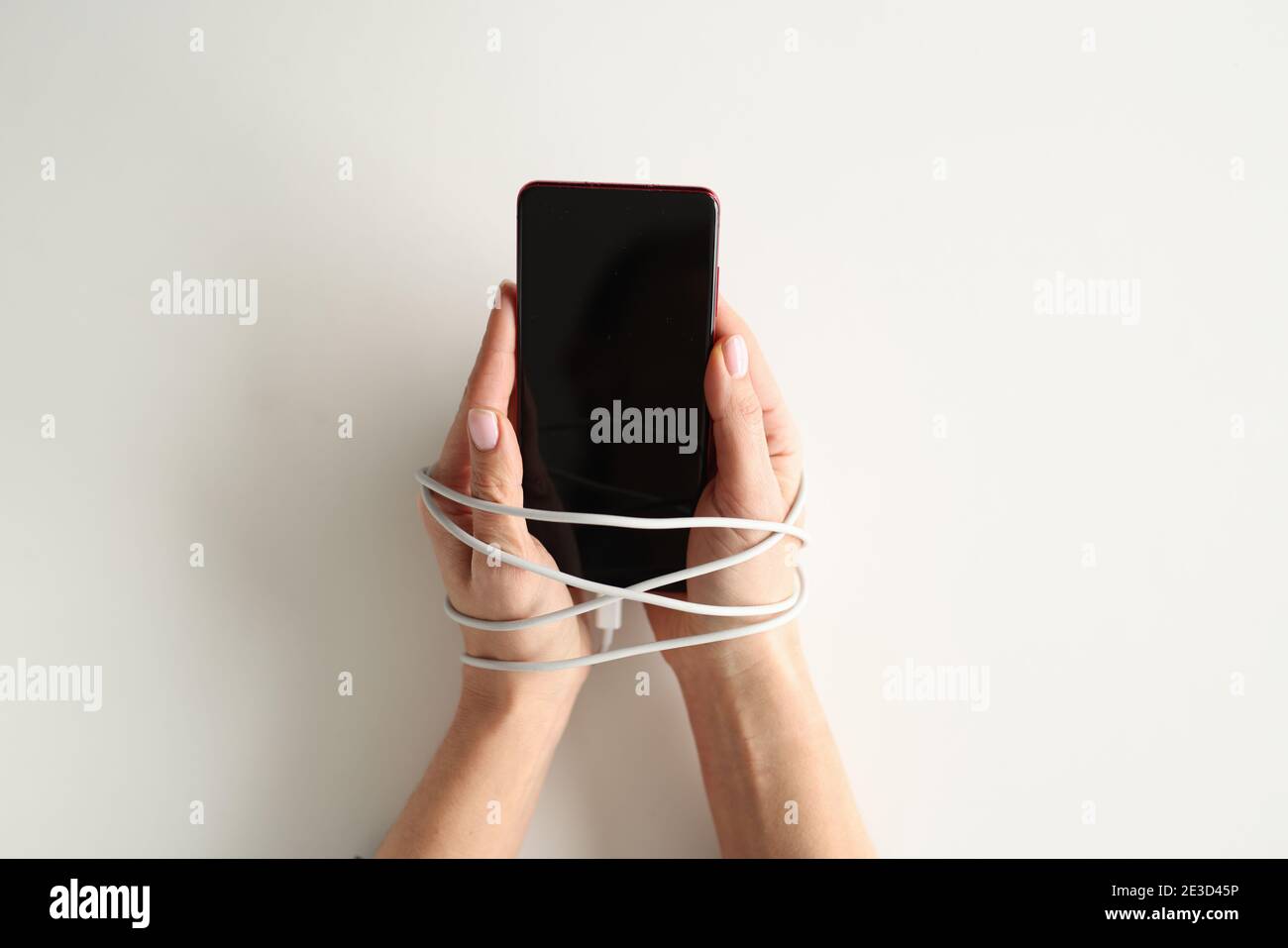 Hands are tied with wire and hold smartphone Stock Photo - Alamy