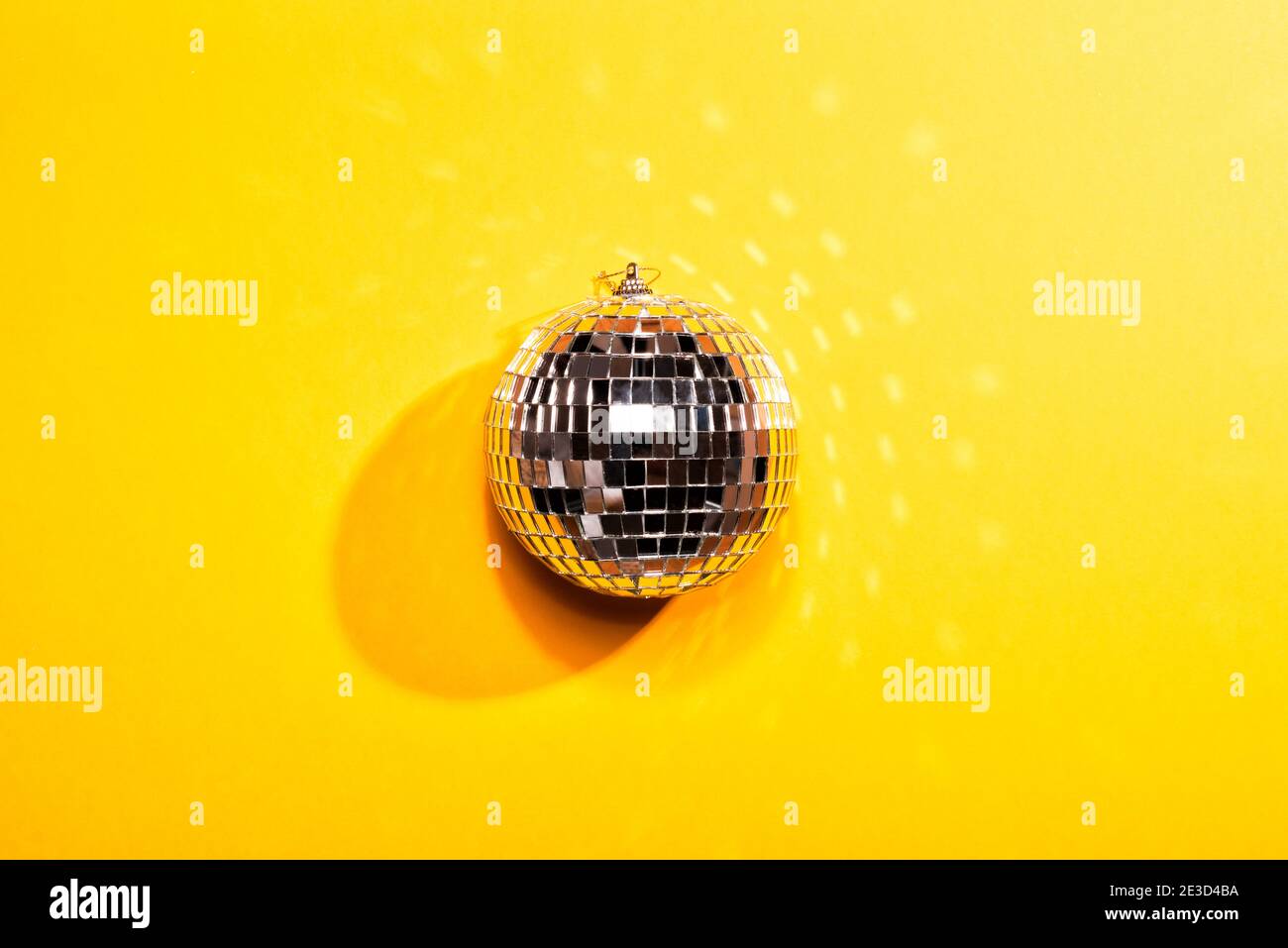 Mirror gray disco ball on yellow illuminating paper background. Party ...