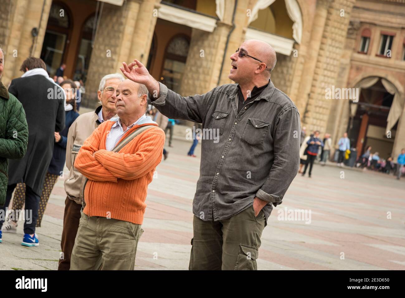 Men talking and debating using hand gestures in the Piazza Maggiore in ...
