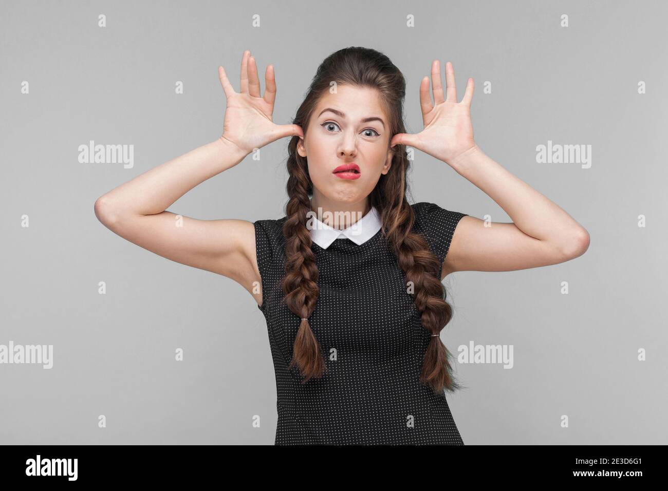 Funny woman showing idiotic and comic face at camera. Indoor, studio ...
