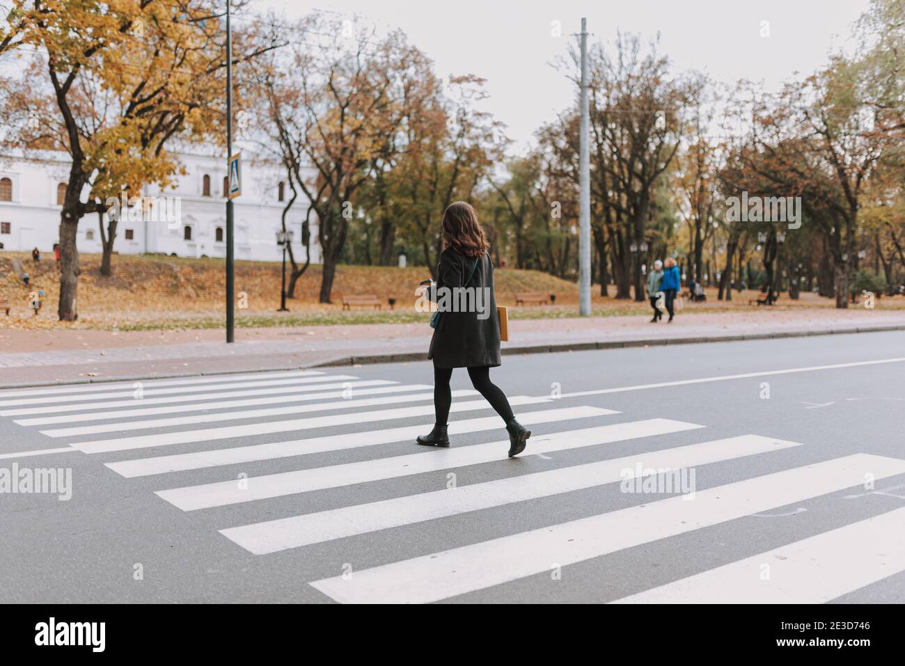 Woman with coffee following the rules and crossing the road on ...