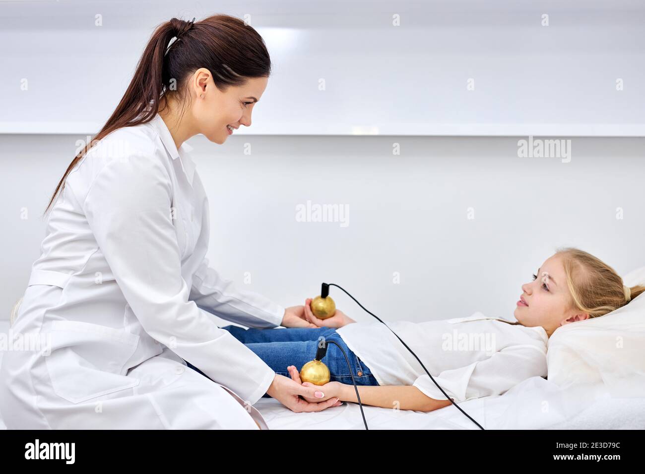 female doctor therapist treating child patient using electrical ...