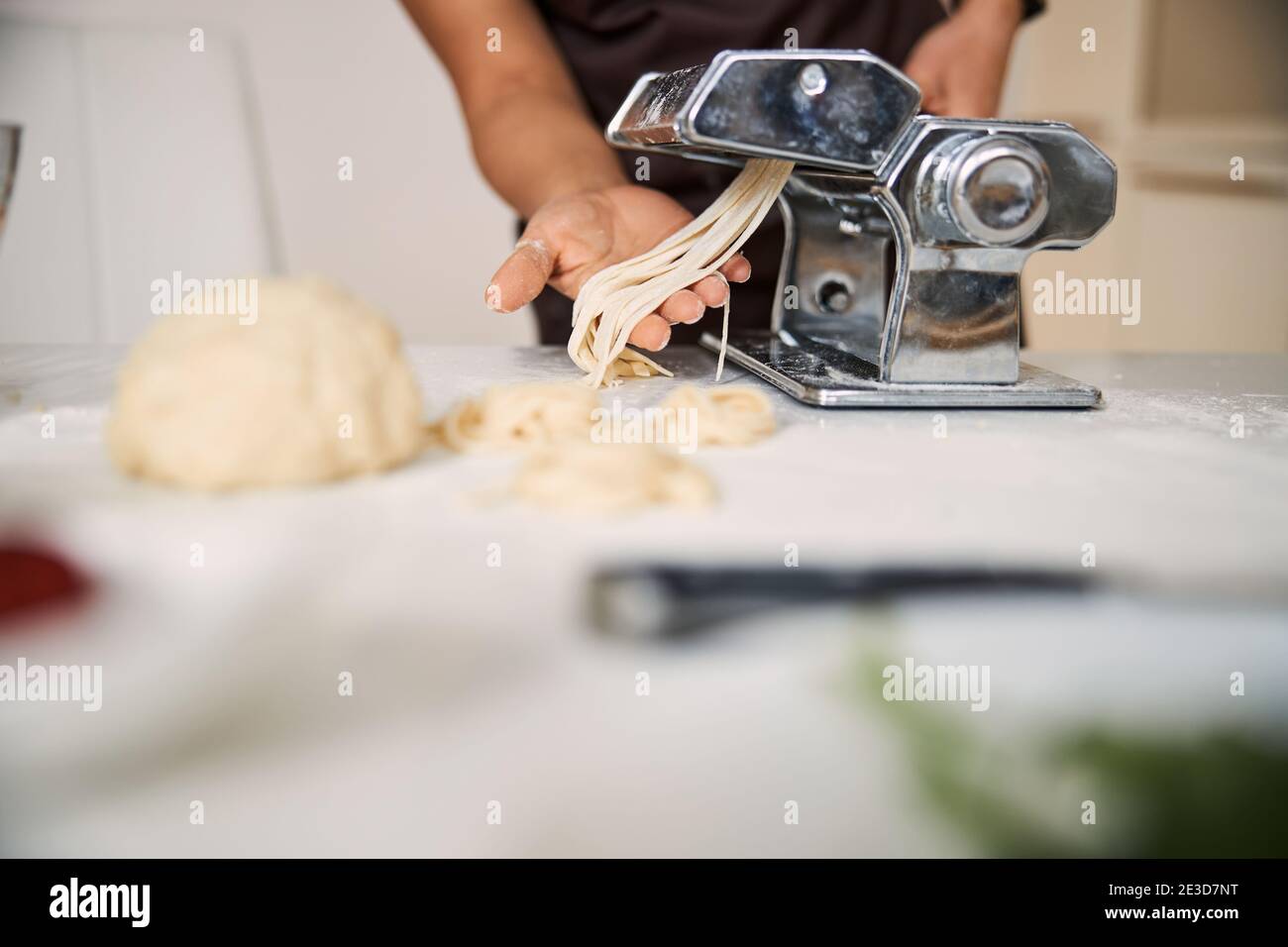 Dough being processed through the pasta machine Stock Photo - Alamy