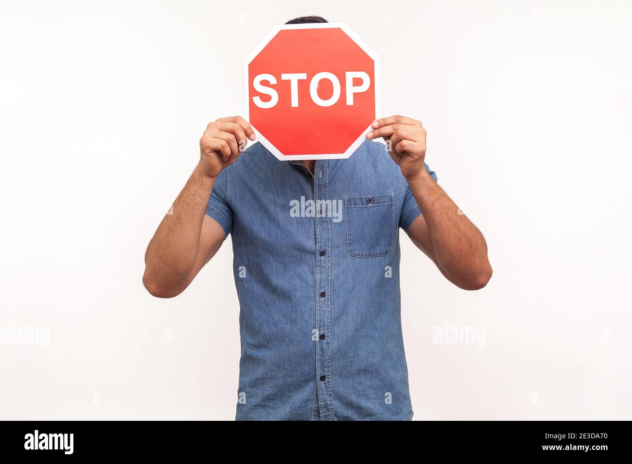 Scared man in blue shirt hiding face behind stop sign, victim of ...