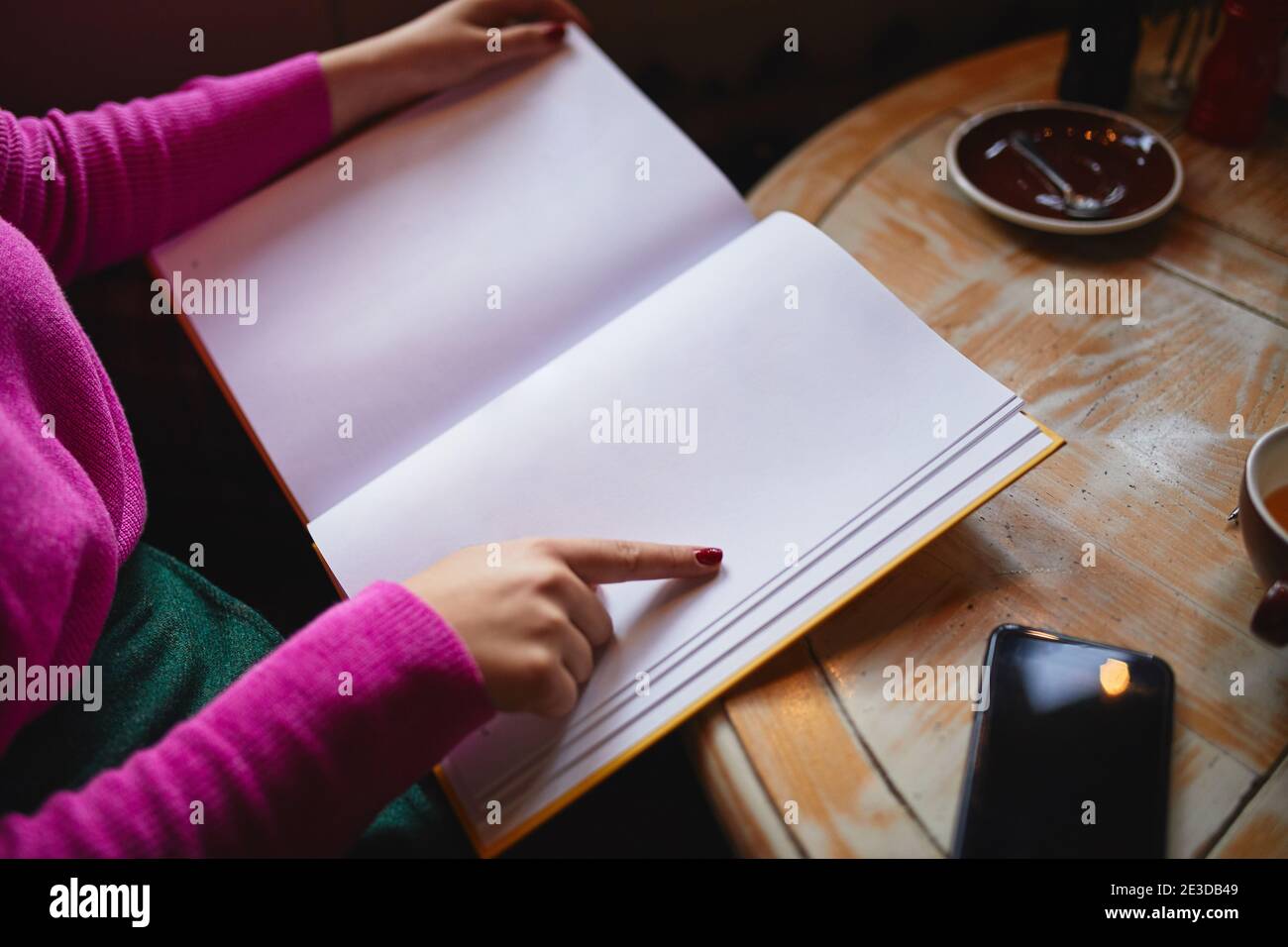 Close up of female hands holding menu and going to place an order in ...