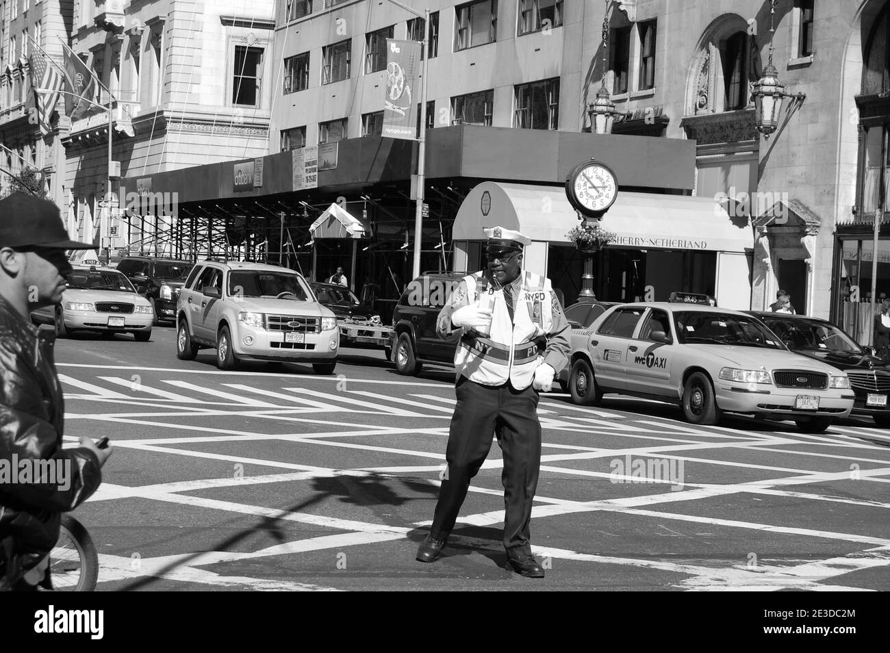 Whistle whistling traffic policeman outside a hotel people crossing the ...