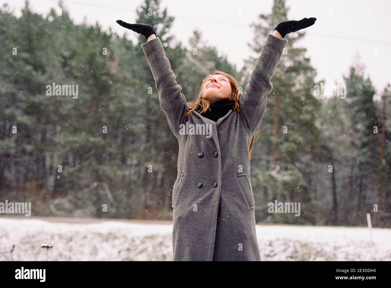 Happy emotions in the winter time. A satisfied young blonde girl holds ...
