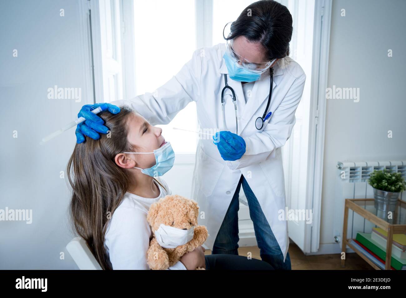 Nurse testing young girl for coronavirus infection taking rapid COVID ...