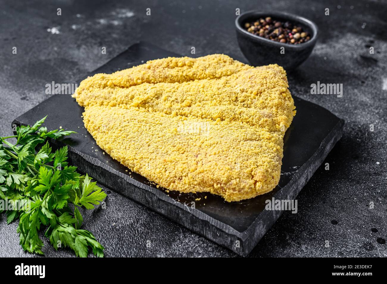 Raw Breaded German Weiner Schnitzel. Black background. Top view Stock ...