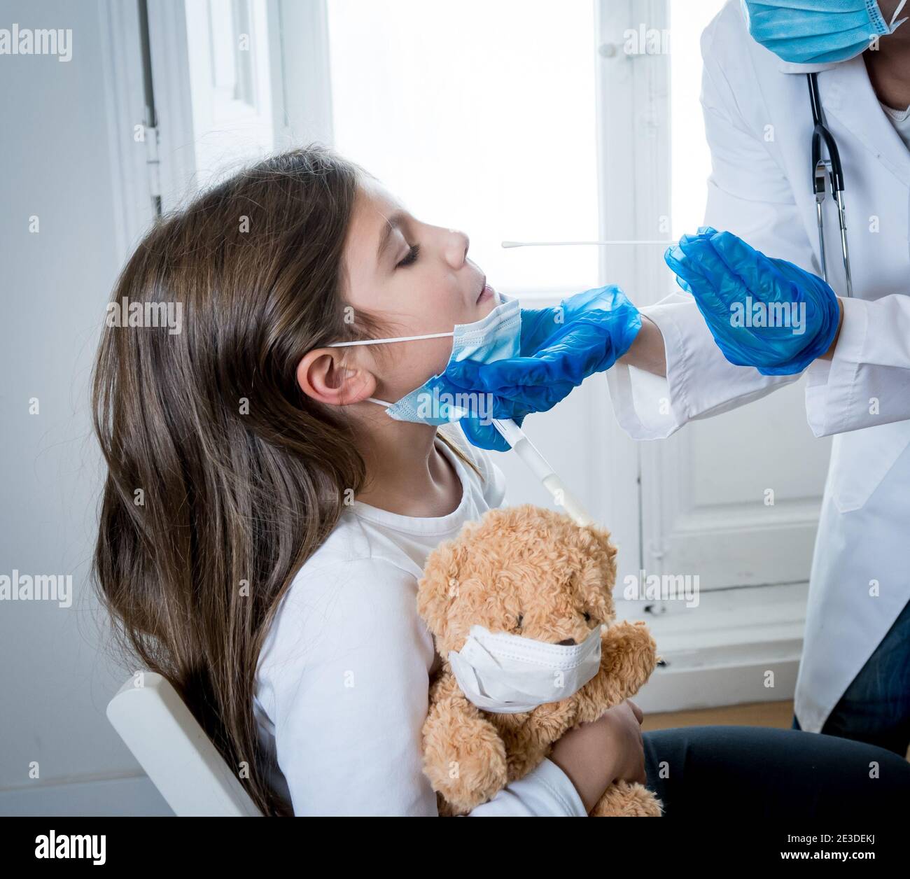 Nurse testing young girl for coronavirus infection taking rapid COVID ...