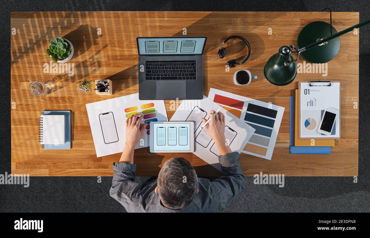 Top view of creative businessman working on computer at desk in home ...