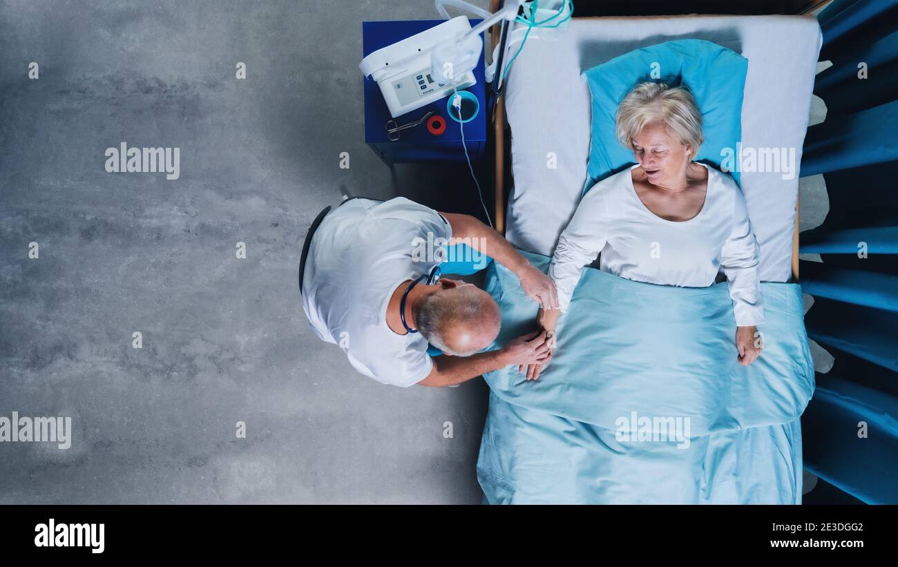 Top view of doctor and patient with iv drip in bed in hospital. Copy ...