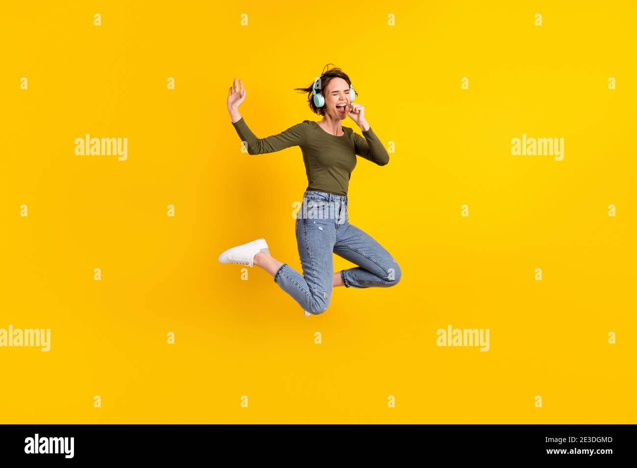 Full length photo of crazy girl jump sing song use hand as mic wear ...