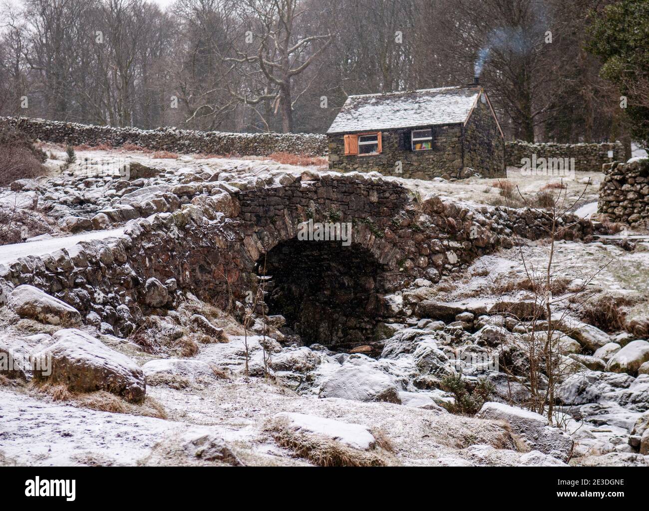 Winter snow lies on the picturesque stone arch bridge and traditional ...