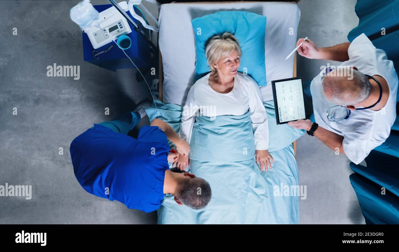 Top view of doctors with stethoscope examining patient in bed in ...