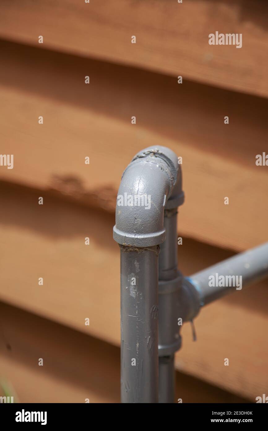 Close up of metal plumbing pipe leading into a home Stock Photo - Alamy