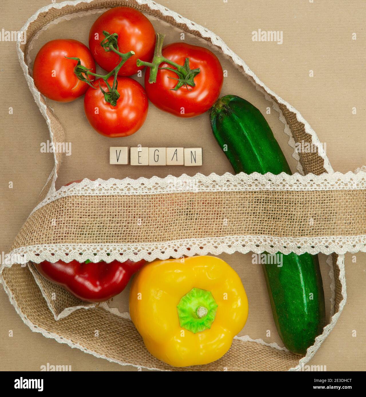 Vegan written with wooden cubes surrounded with fresh organic ...