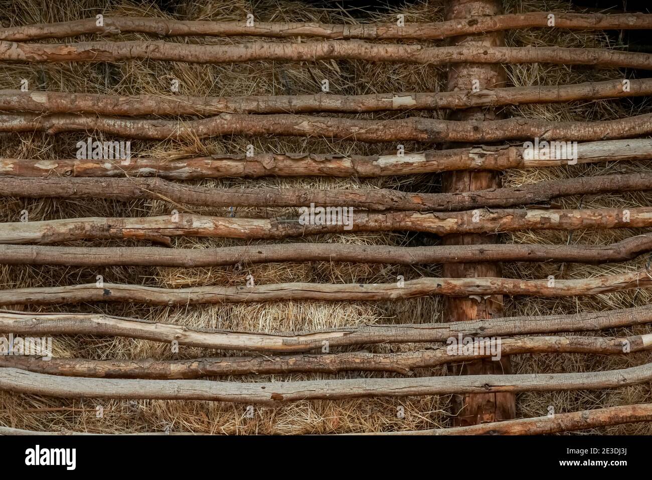 Wall of wood and straw. The exterior of the old rustic stable. Place ...