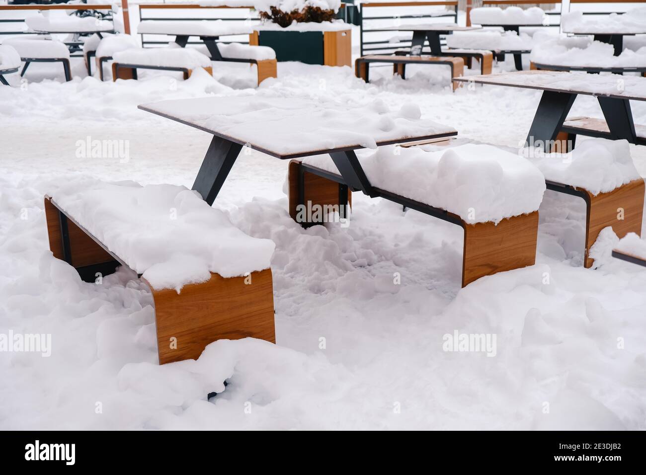 Tables and benches of outdoor cafes, covered with snow Stock Photo - Alamy