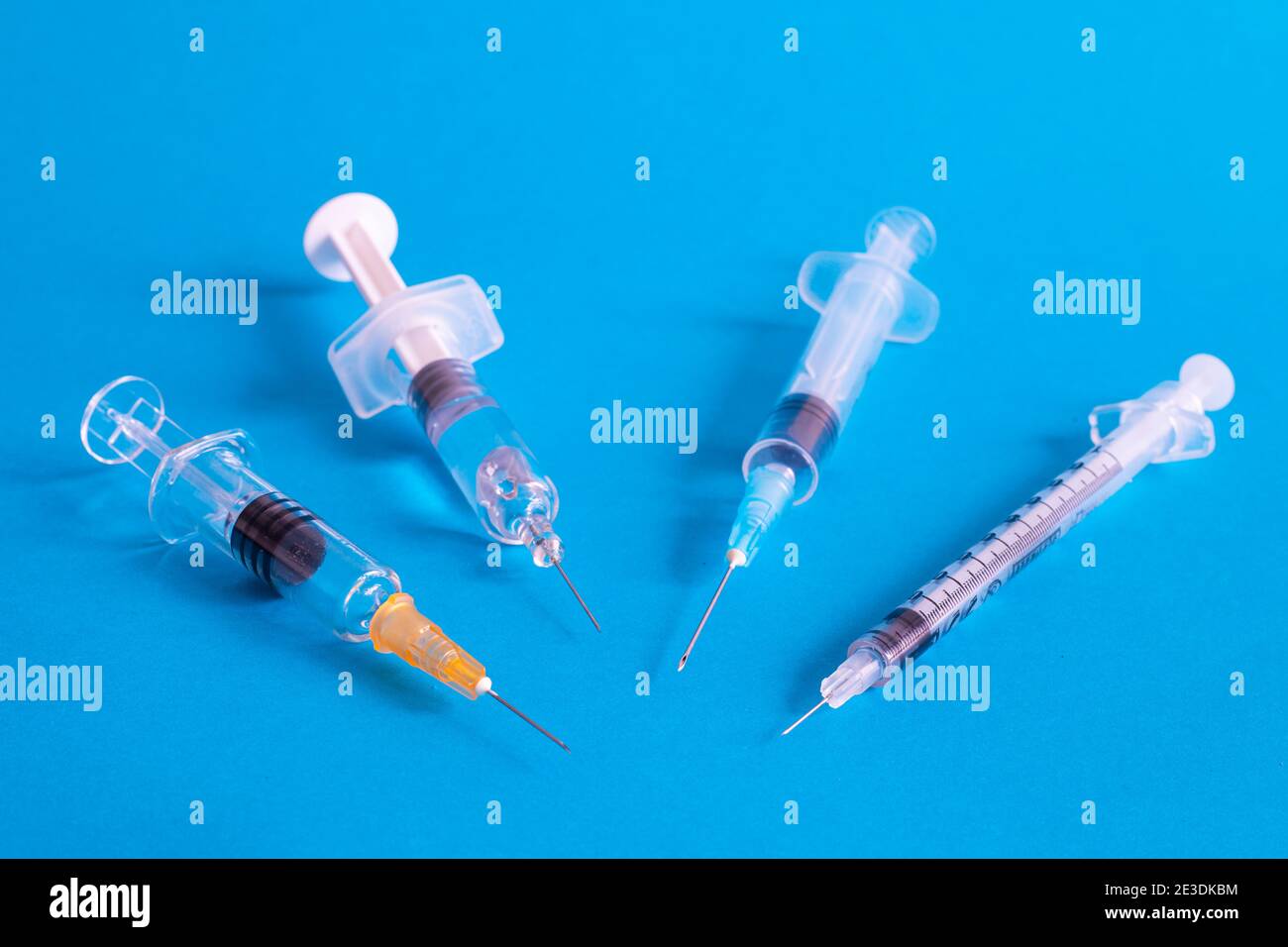 High angle shot of different syringe needles with the vaccine against a ...