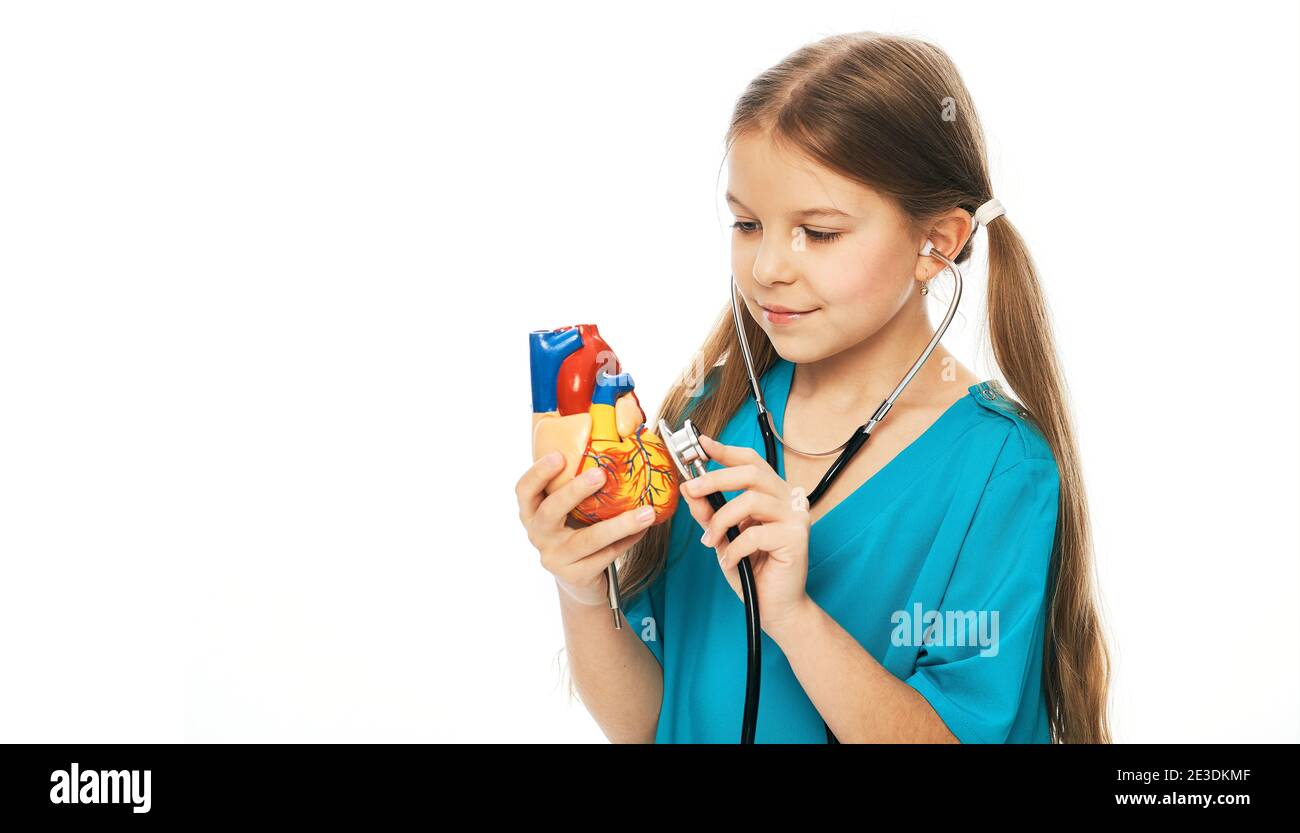Cute little girl listens to the heart using a stethoscope. Child ...