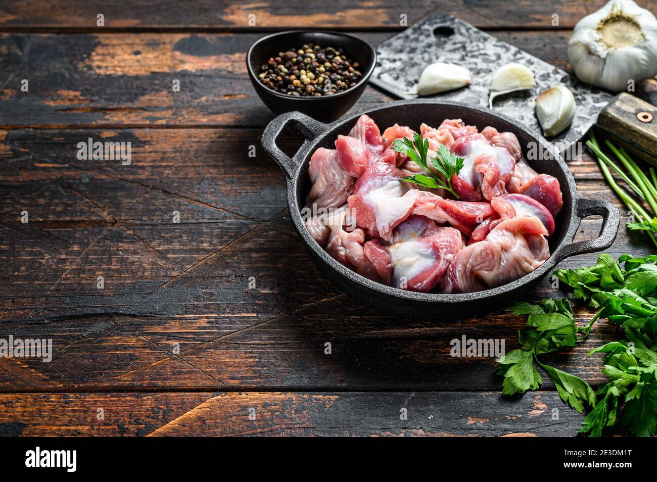 Raw uncooked Bird chicken giblets gizzards, stomachs in a pan. Black ...