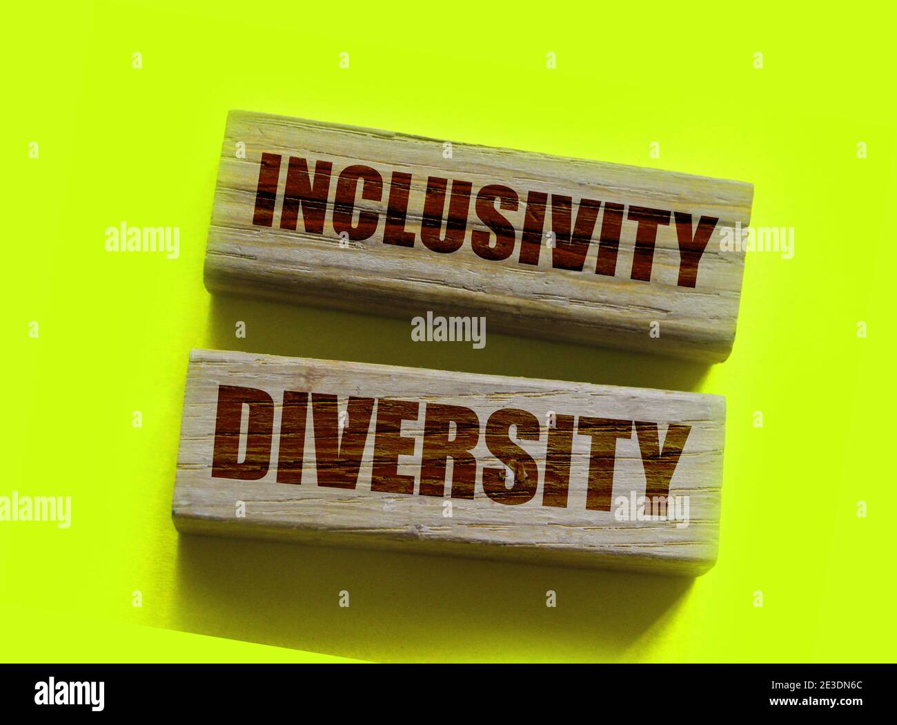 Inclusivity diversity words on wooden block on the yellow background ...